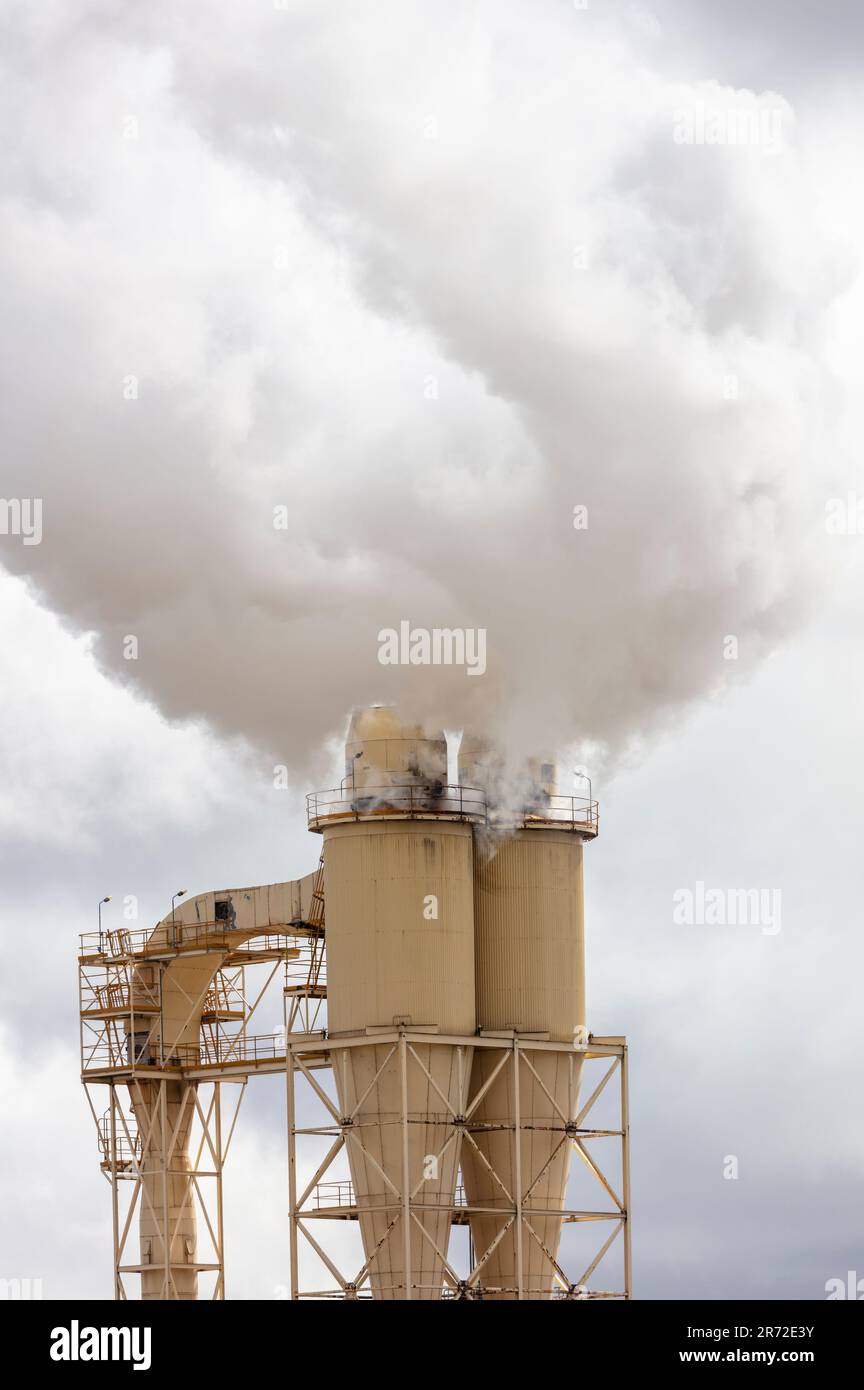 Photograph of steam coming from a chimney against a grey cloudy sky at ...