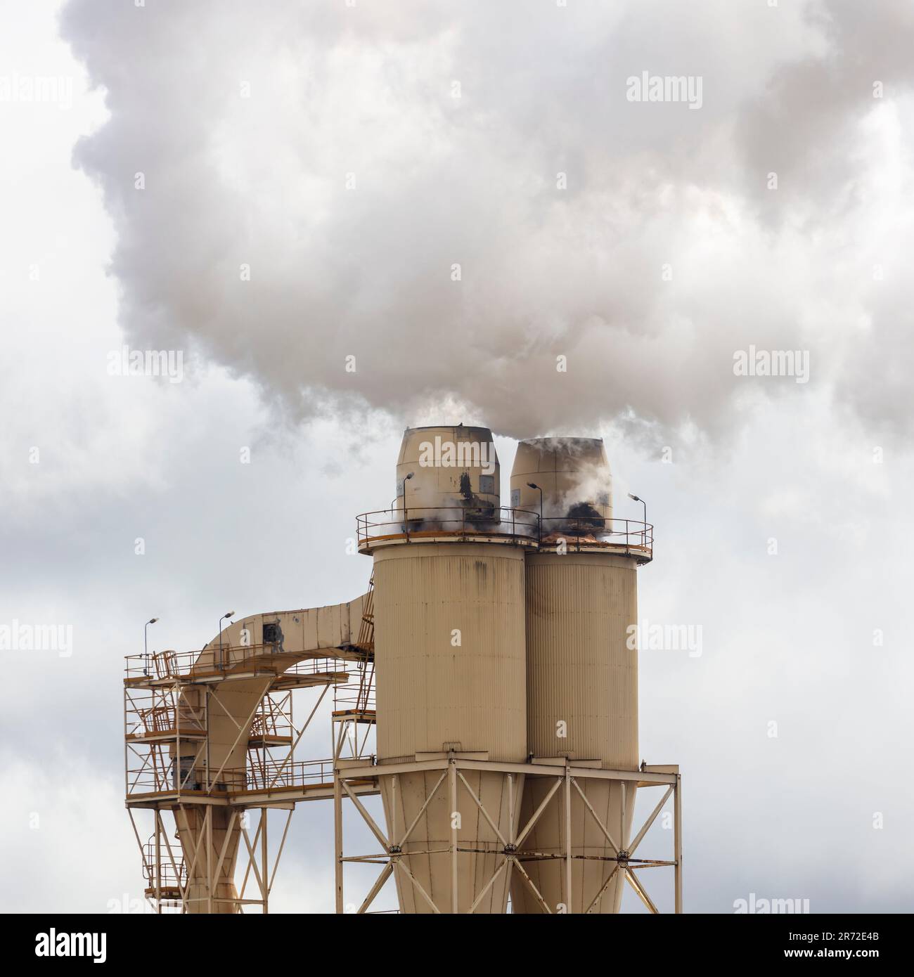 Photograph of steam coming from a chimney against a grey cloudy sky at ...