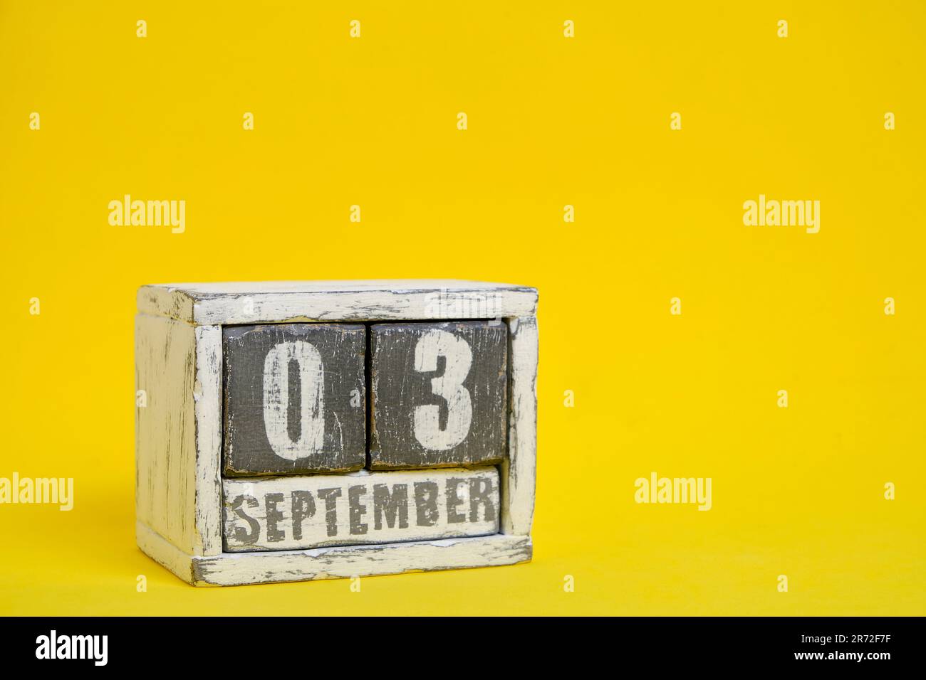 September 03 wooden calendar standing yellow background with an empty ...