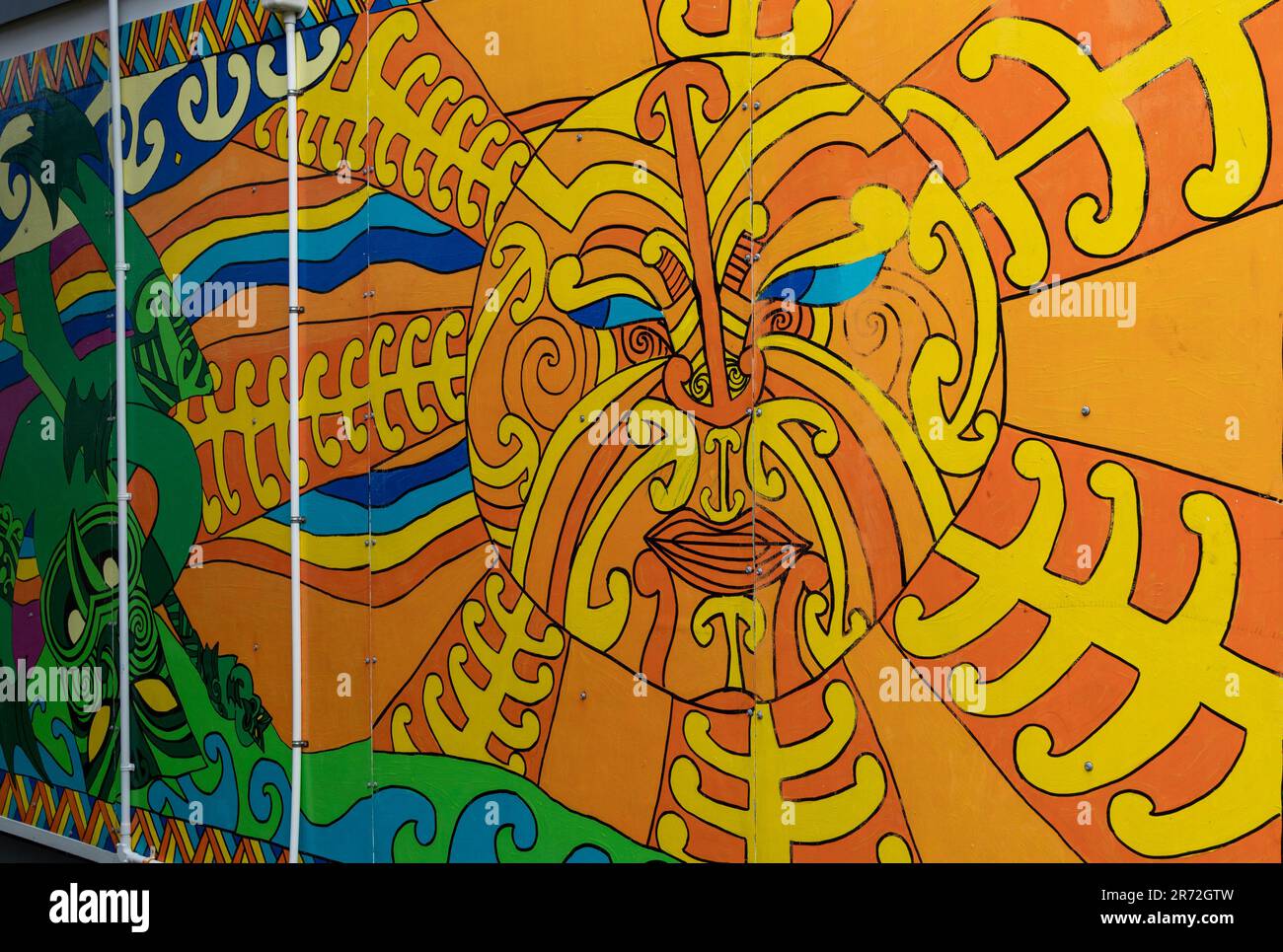 A multicolored abstract painting of the sun on a school building, in ...