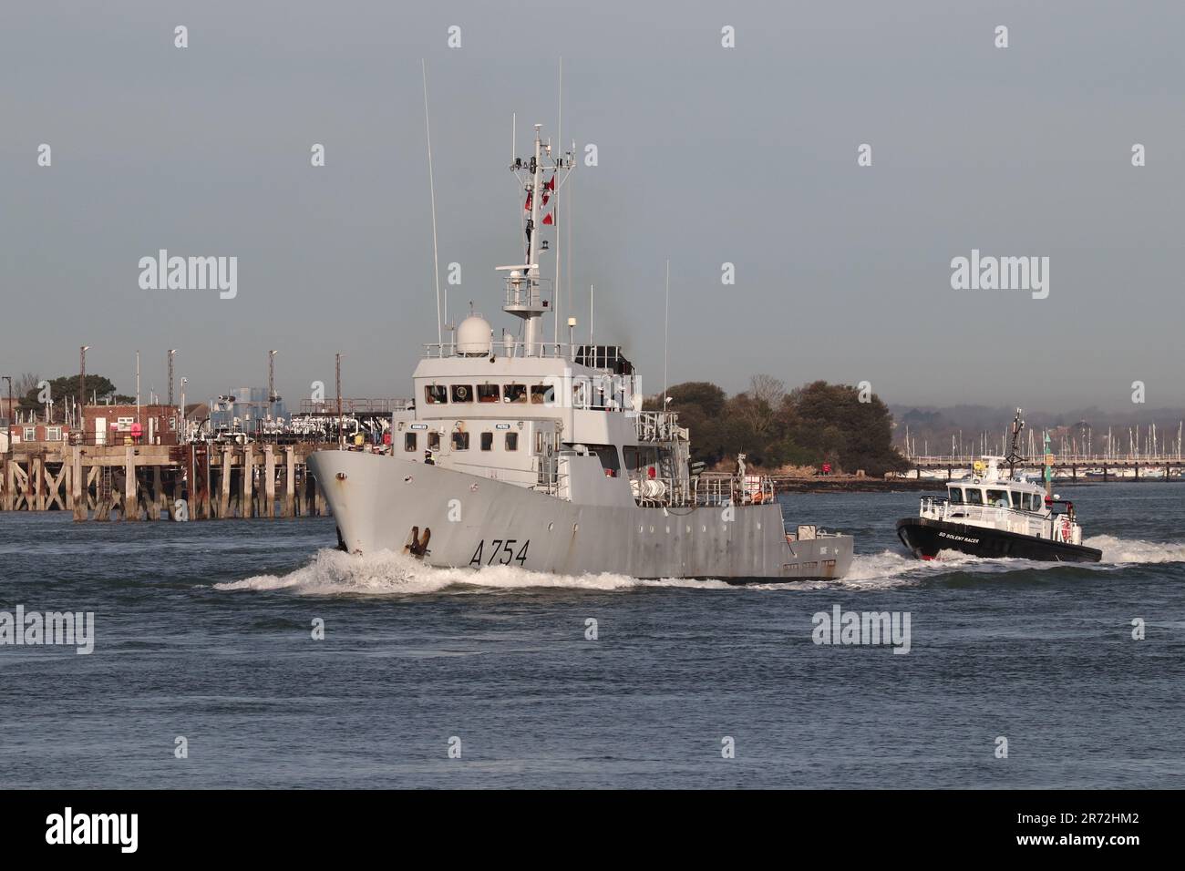 An Admiralty Pilot launch stays close to the stern of the French Naval ...