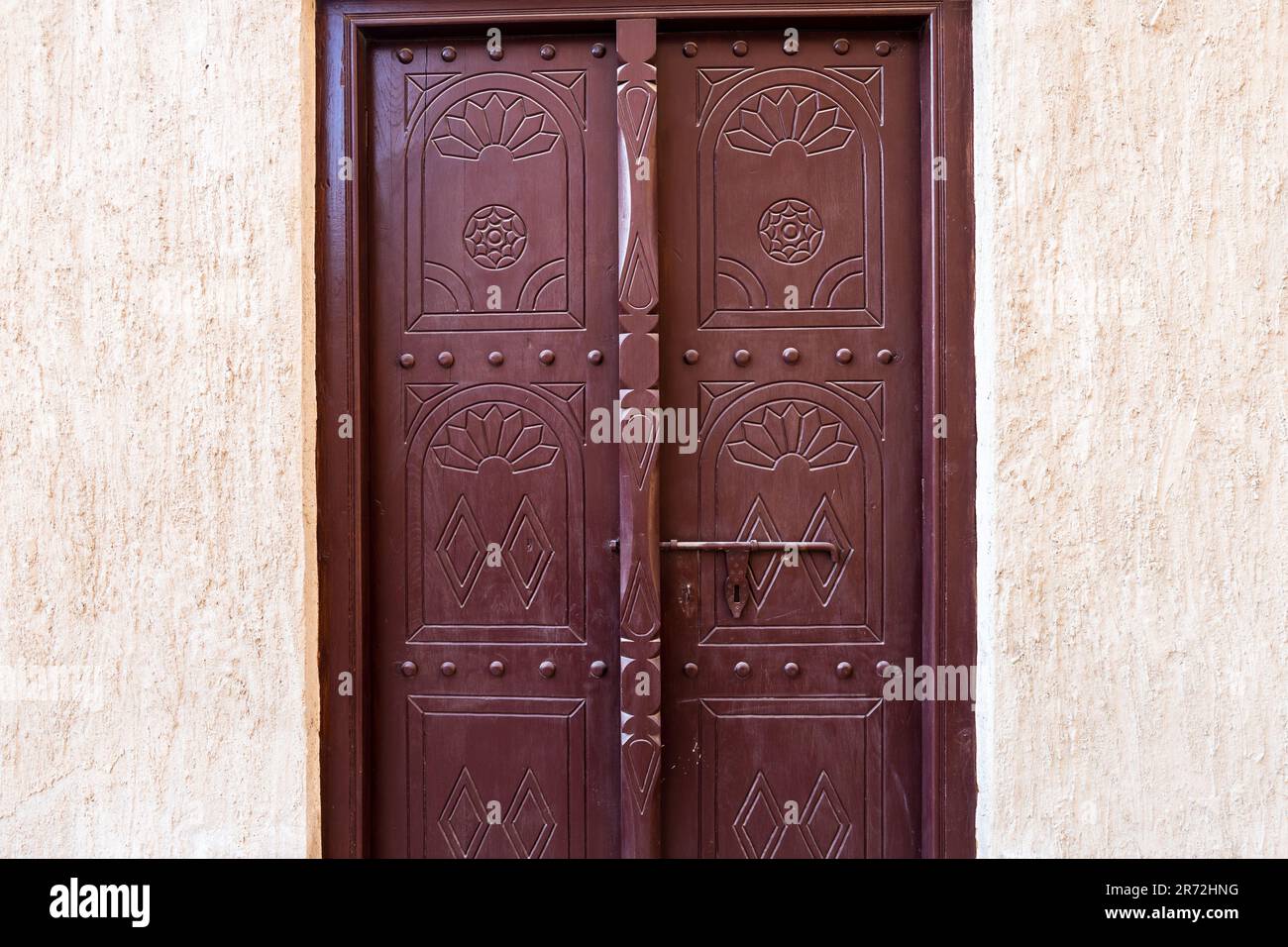 A brown painted wooden door with geometric designs adorning the surface ...