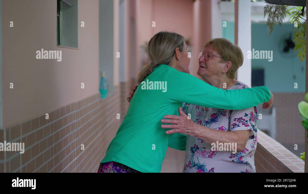 Warm family reunion, adult daughter embracing elderly mother ...