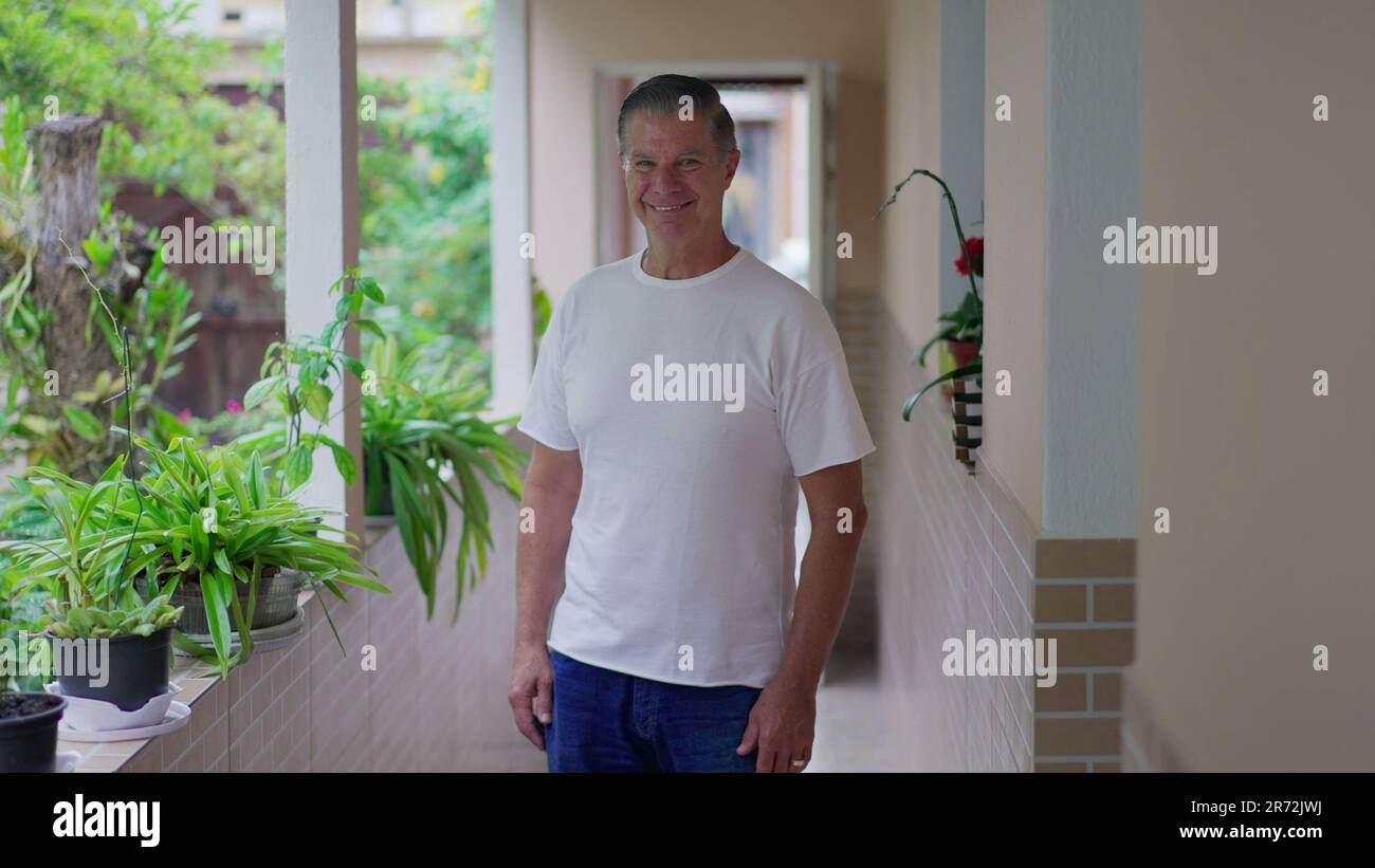 Happy retired older man smiling at camera while standing in home ...
