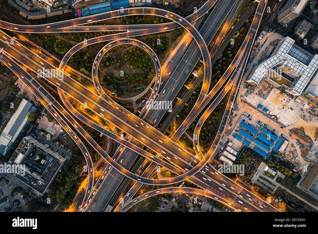Aerial shot of a bustling city intersection at night with cars driving ...