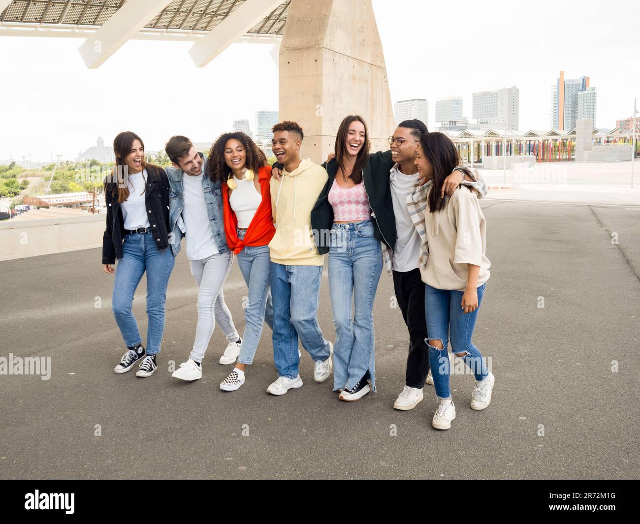 Group of diverse student teenagers walking embraced in a city ...