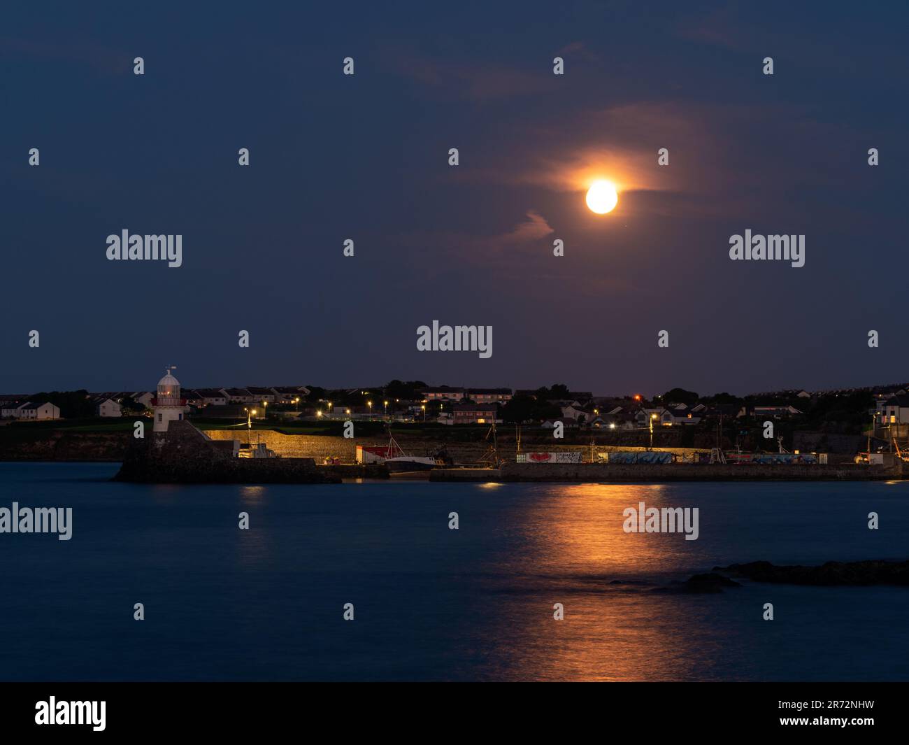 Moonlight from the rising Strawberry Moon over Balbriggan Harbour Stock ...