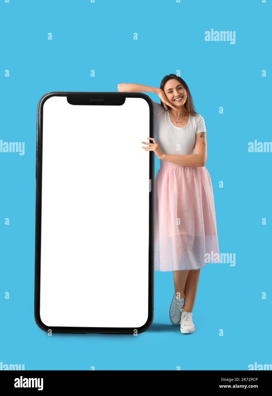 Happy young woman standing near big mobile phone with blank screen on ...