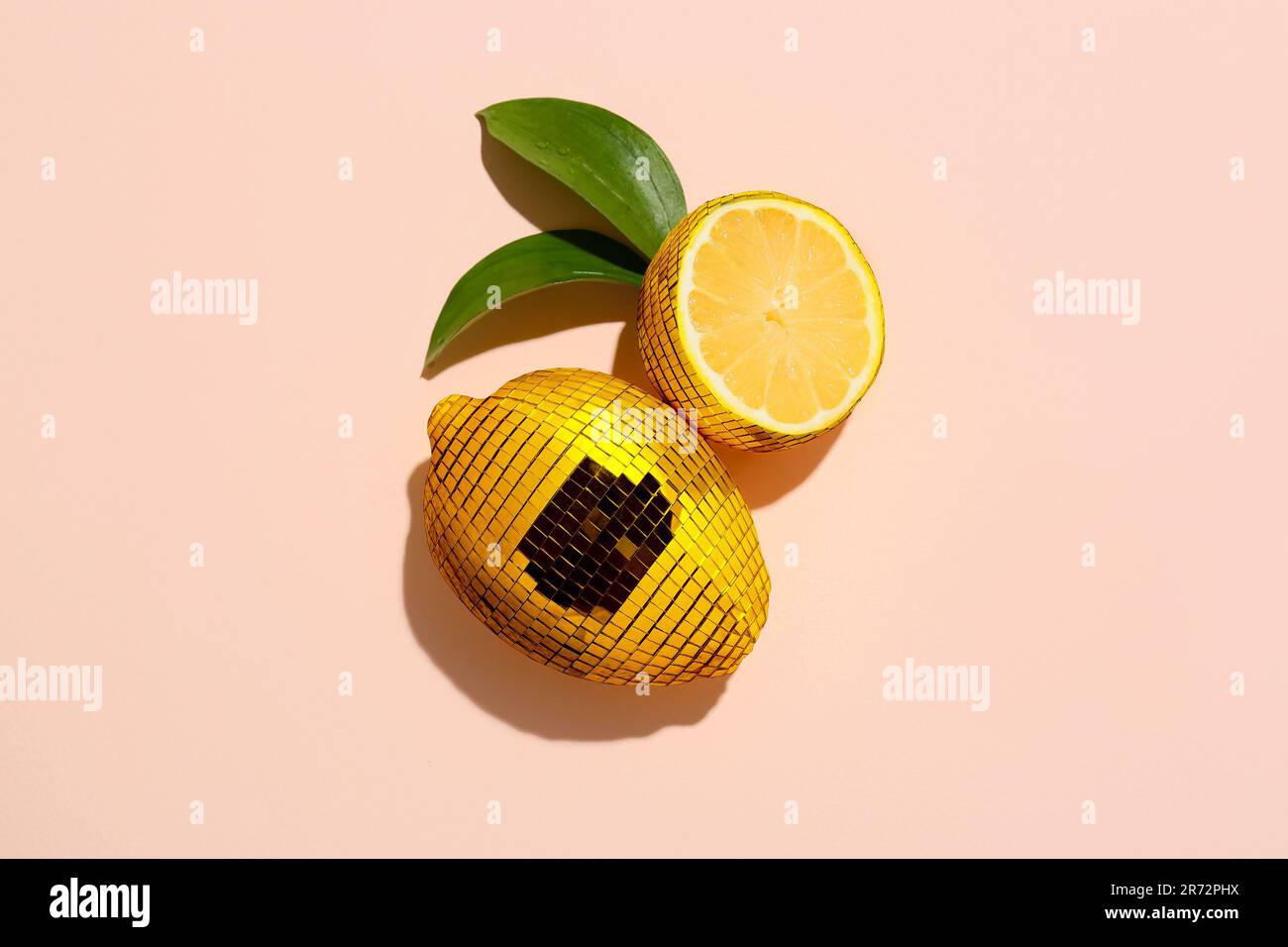 Disco balls with lemon inside on beige background Stock Photo - Alamy