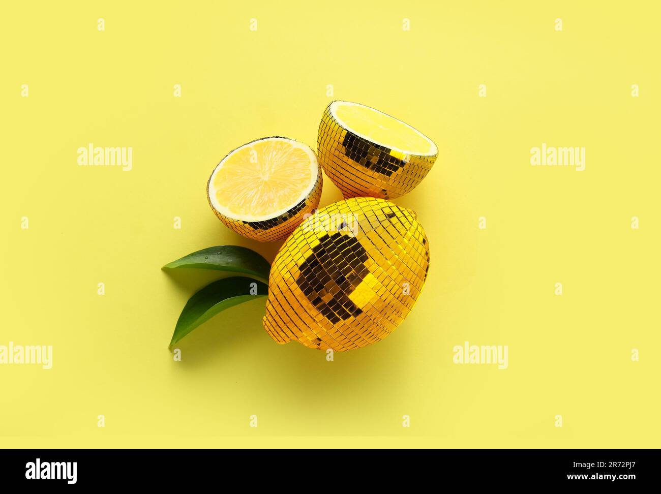 Disco balls with lemon inside on yellow background Stock Photo - Alamy