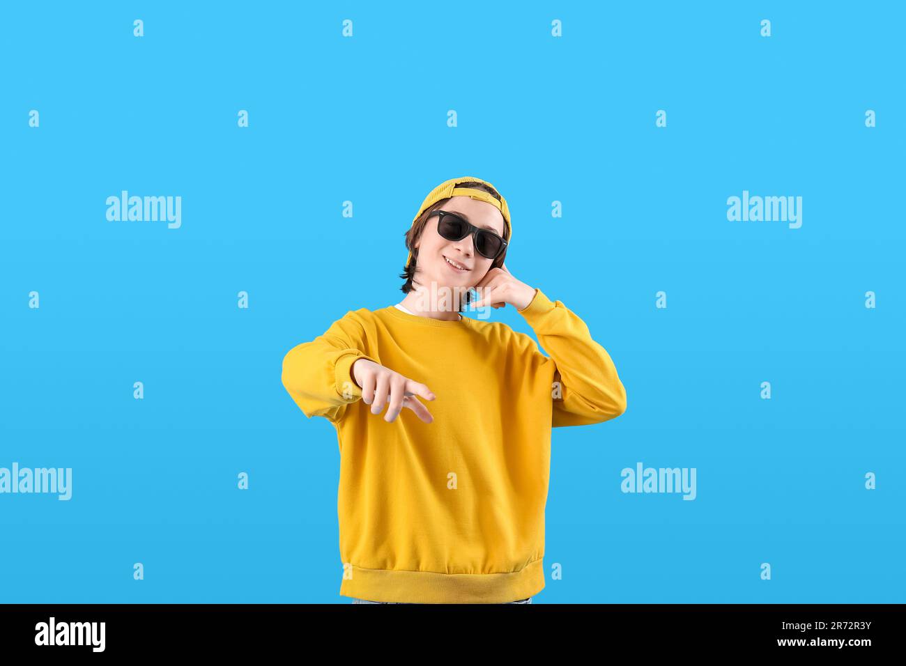 Cool teenage boy showing "call me" gesture on blue background Stock ...
