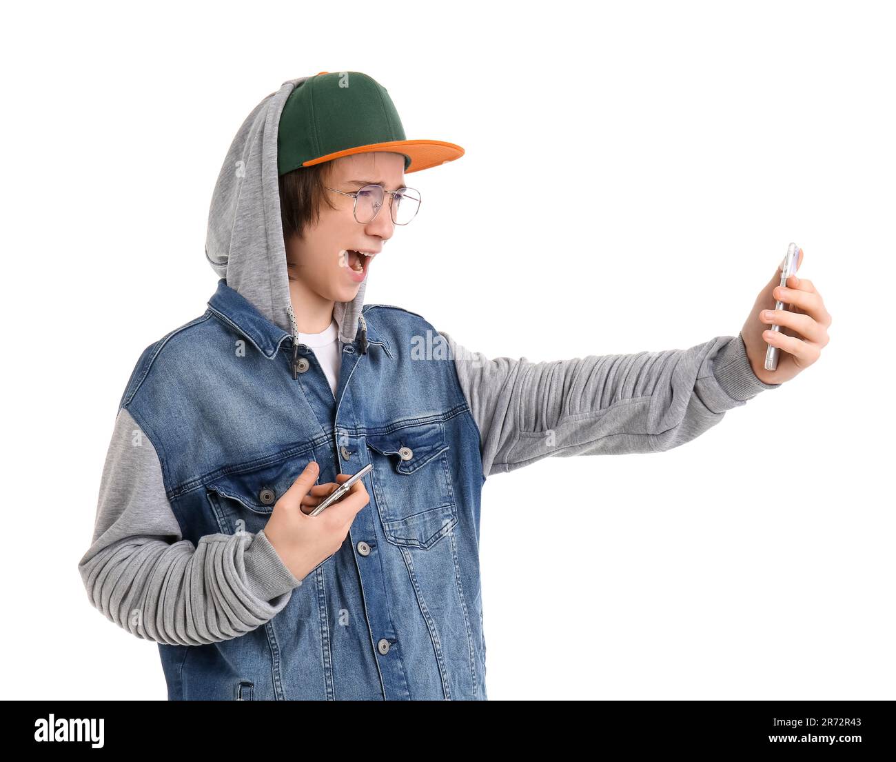 Cool teenage boy with mobile phones shouting on white background Stock ...
