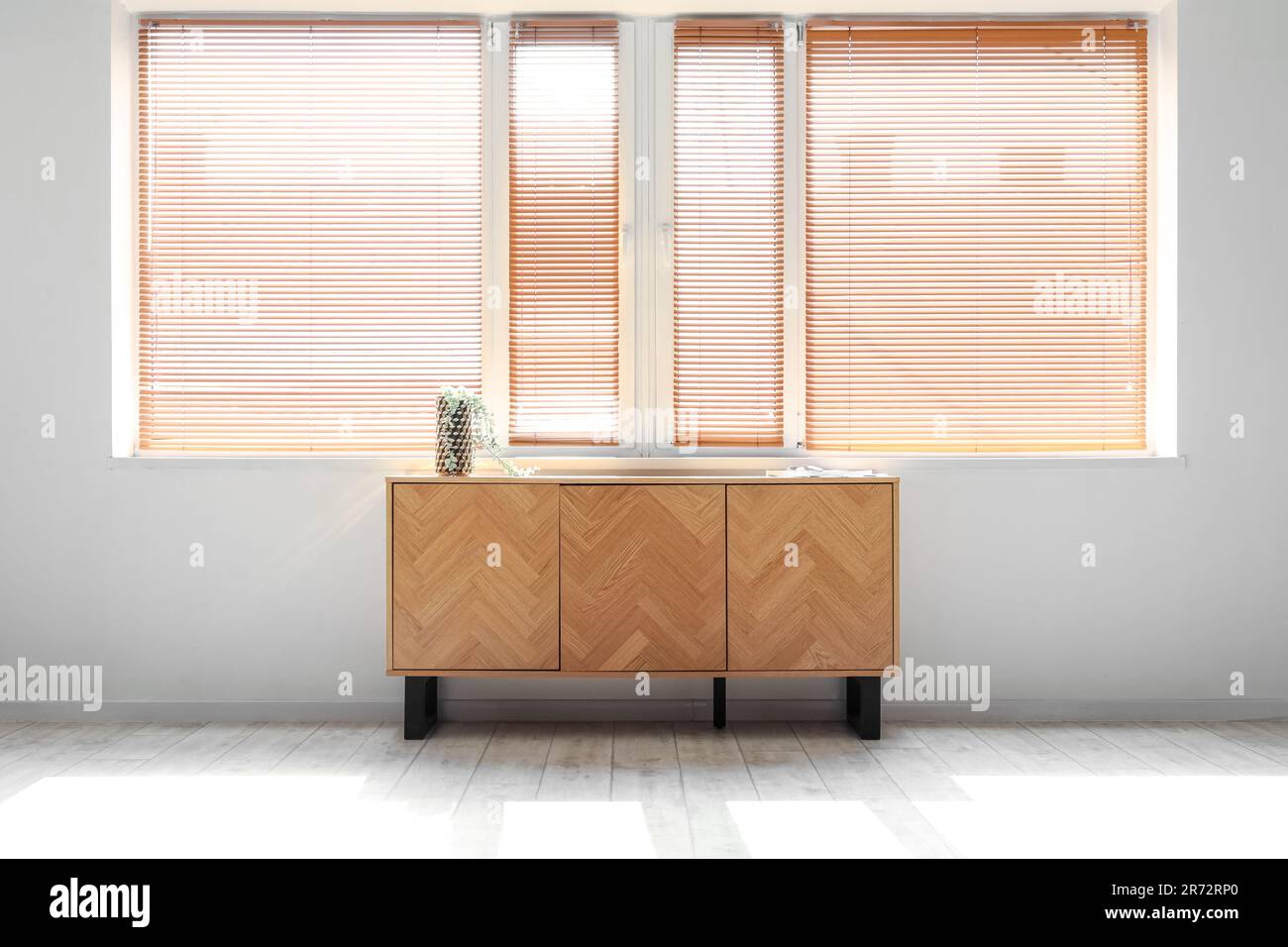 Stylish wooden cabinet near window with blinds Stock Photo - Alamy