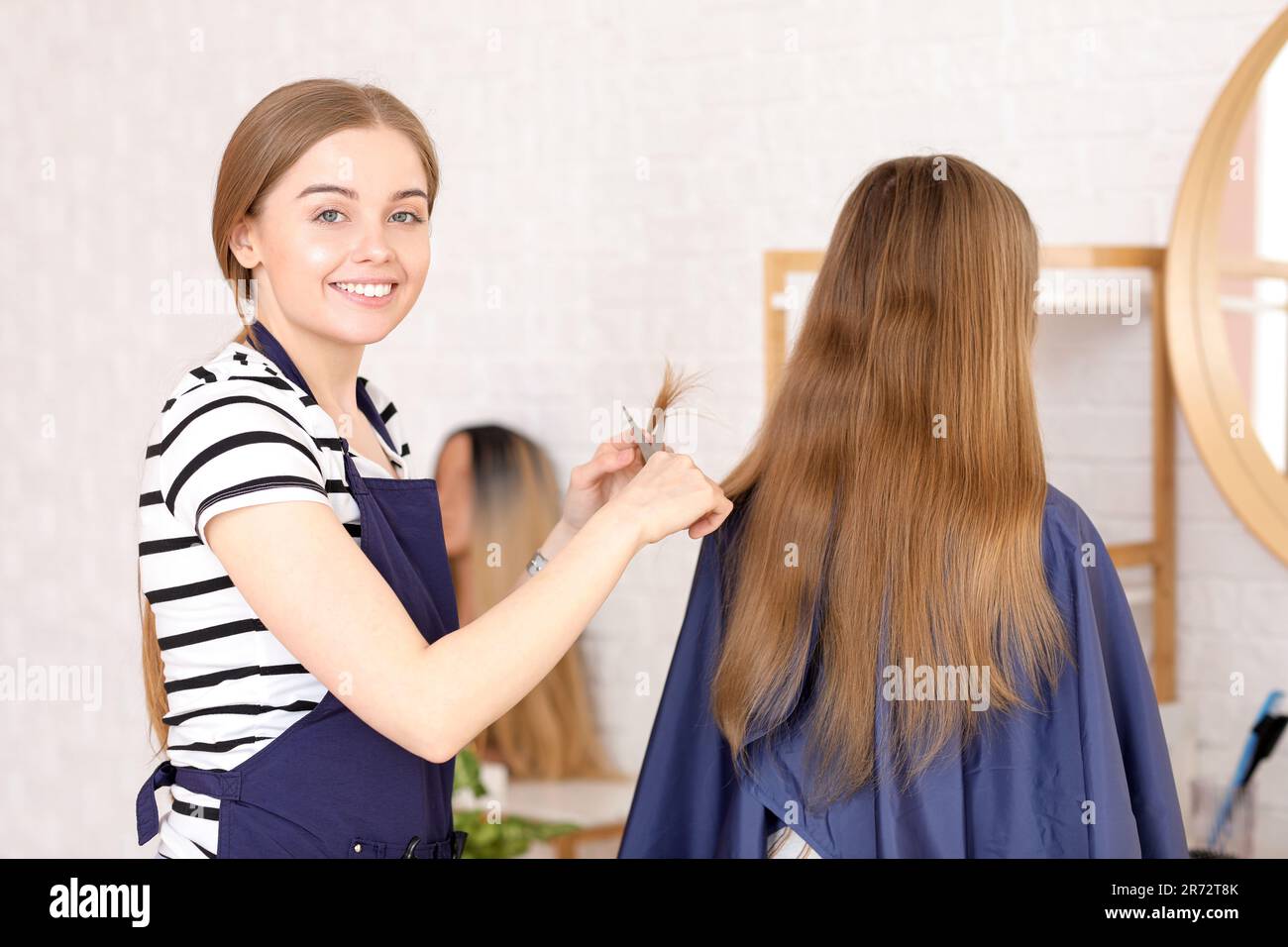 Female hairdresser cutting young woman's hair in beauty salon Stock ...