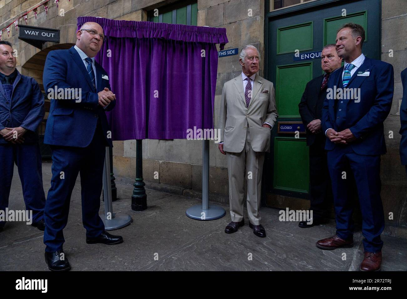 King Charles III unveils a plaque during a visit to Pickering in ...