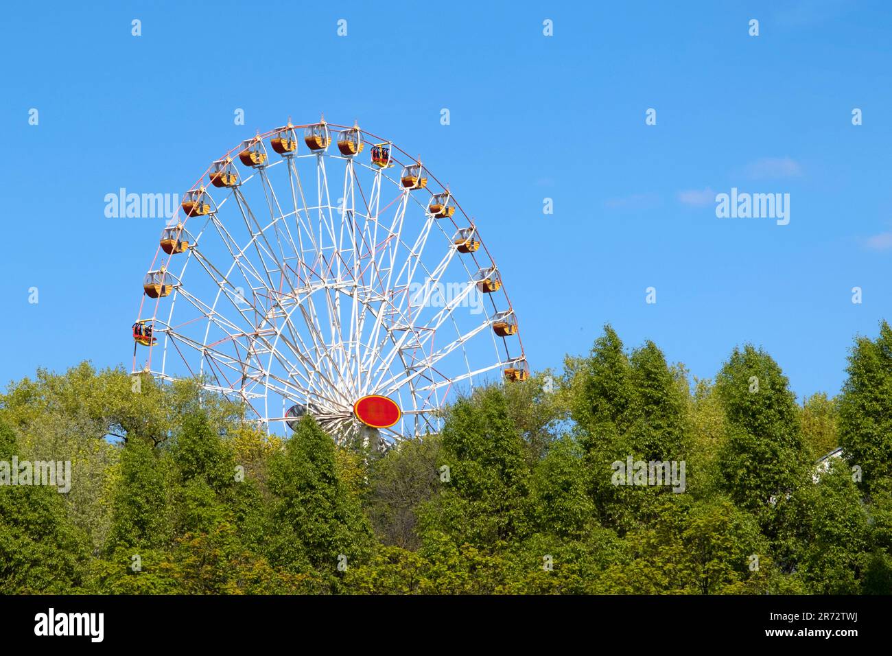 Colorful ferris wheel on blue sky background Stock Photo - Alamy