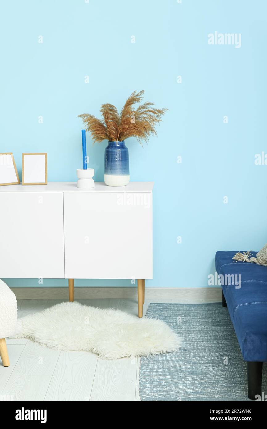 Stylish interior of living room with drawers, sofa and soft rugs Stock ...