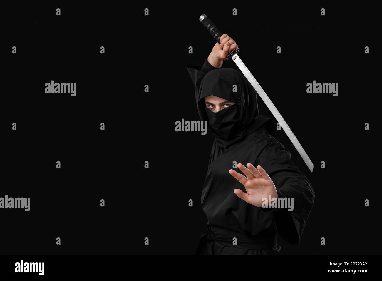 Male ninja with sword on black background Stock Photo - Alamy