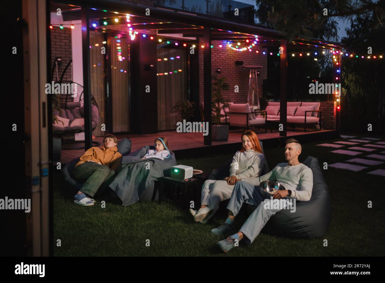 family mother, father and children watch a projector, movies with ...