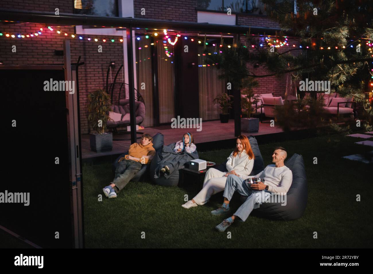 family mother, father and children watch a projector, movies with ...