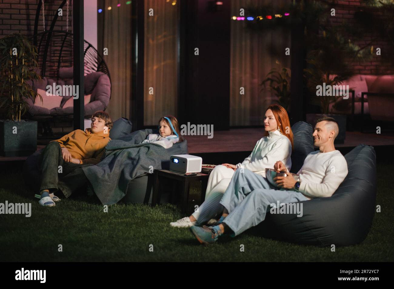 family mother, father and children watch a projector, movies with ...
