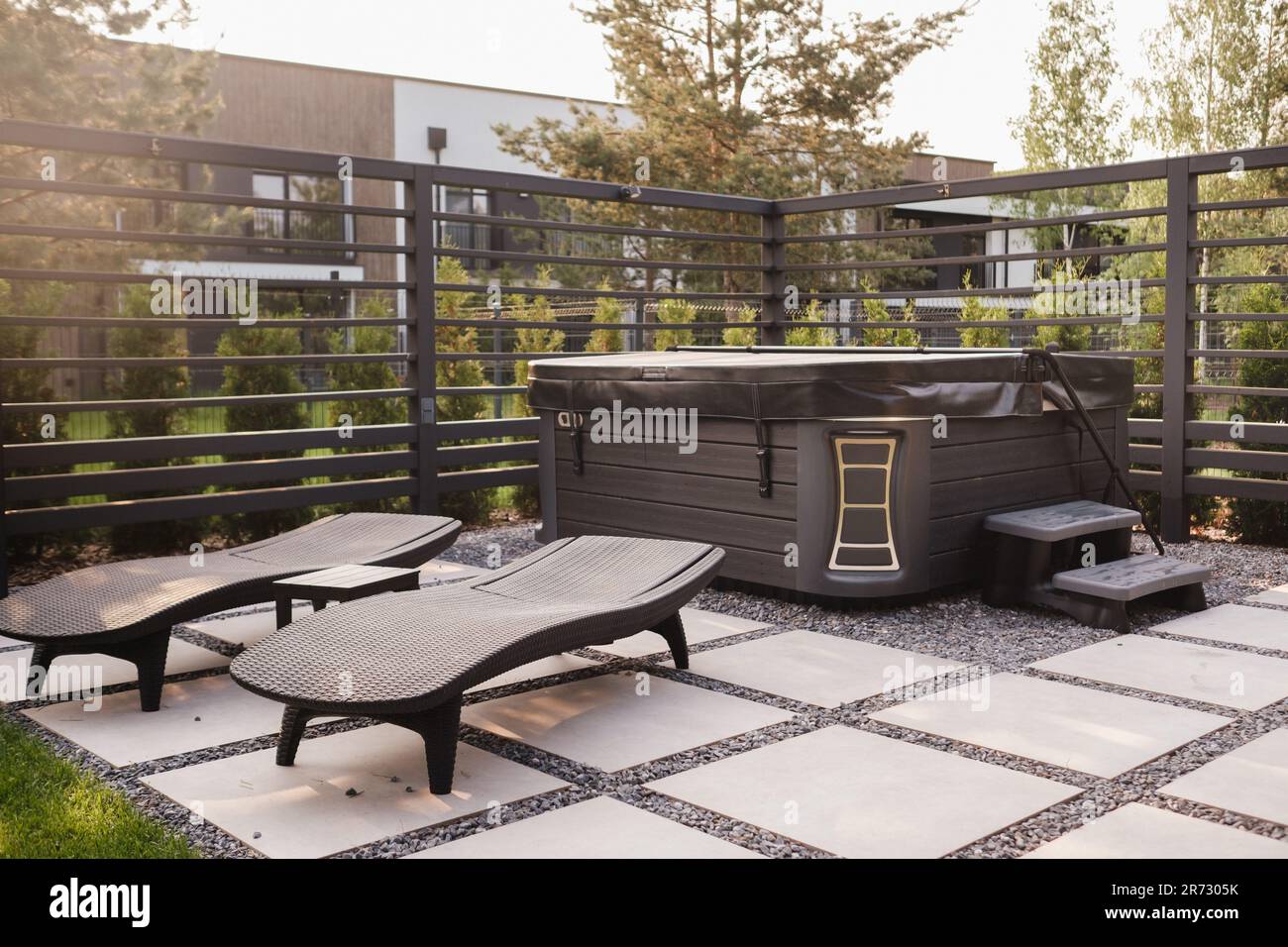 A hot tub and sun loungers in a country house. On the terrace there is ...