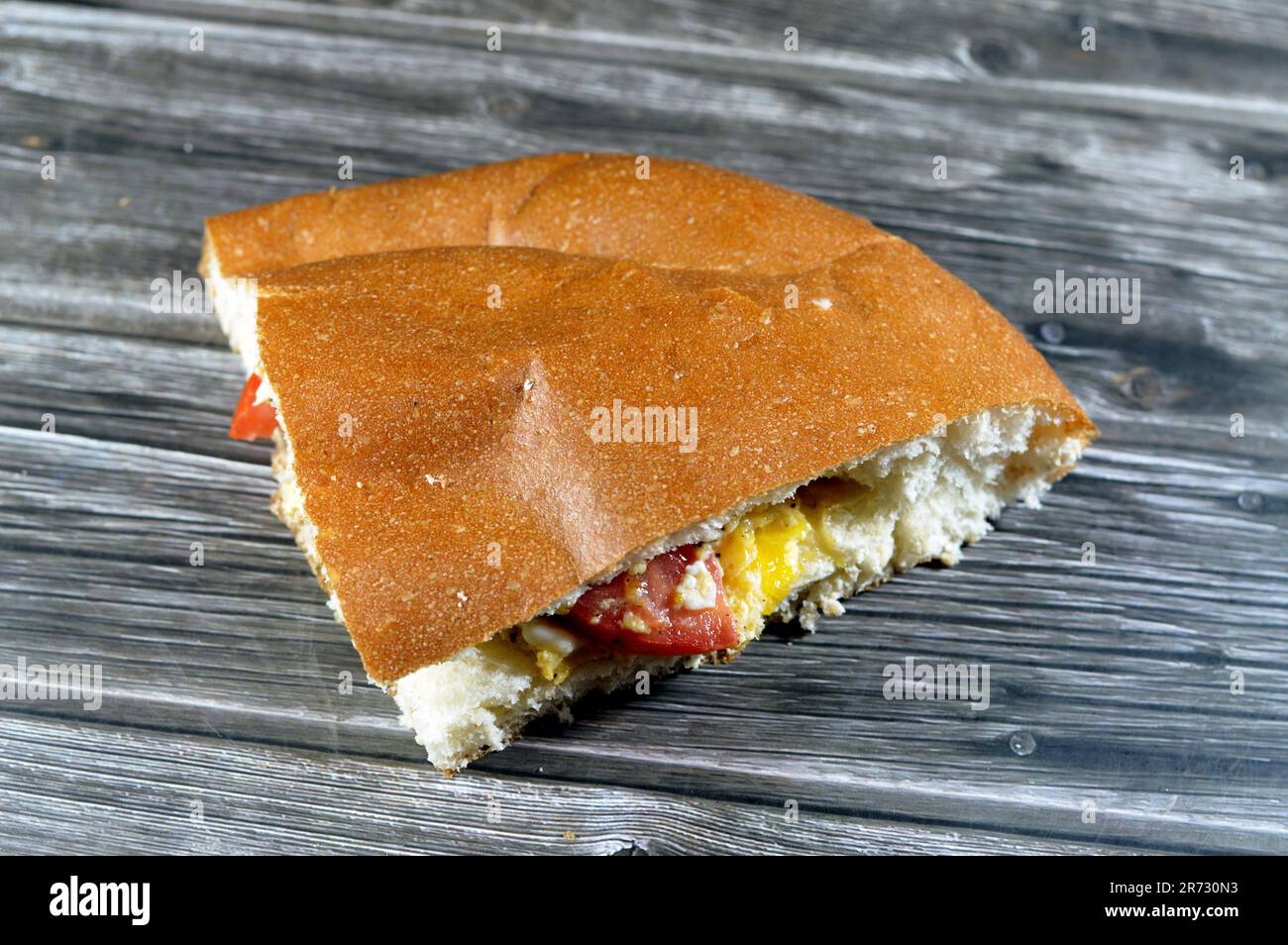 Fried eggs with slices and pieces of tomatoes in a Turkish Pitta bread ...