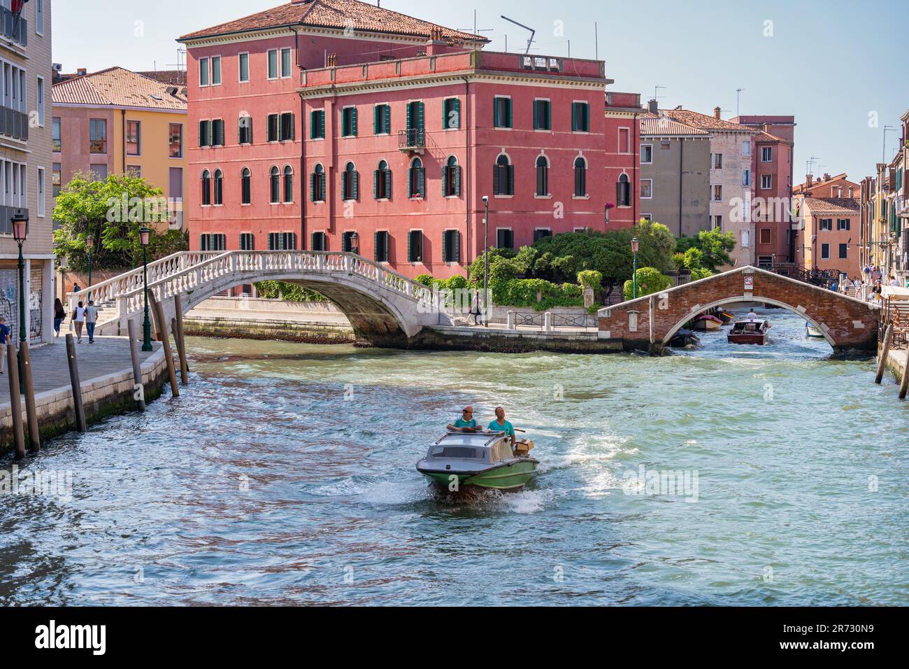 Scene from Venice with stone bridges over the water canals and the boat ...
