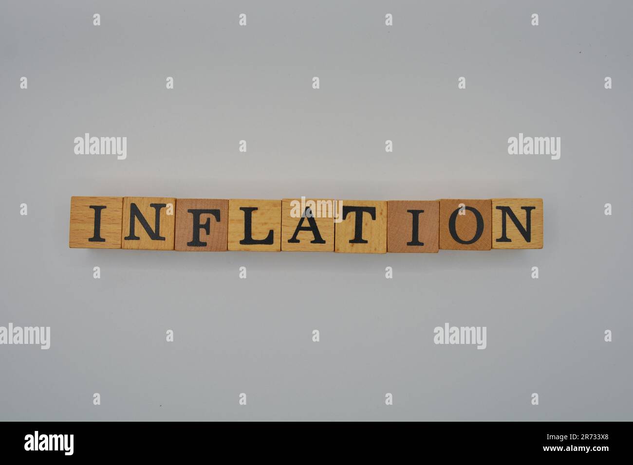 A wooden sign displaying the word 'Inflation' in black lettering on a ...