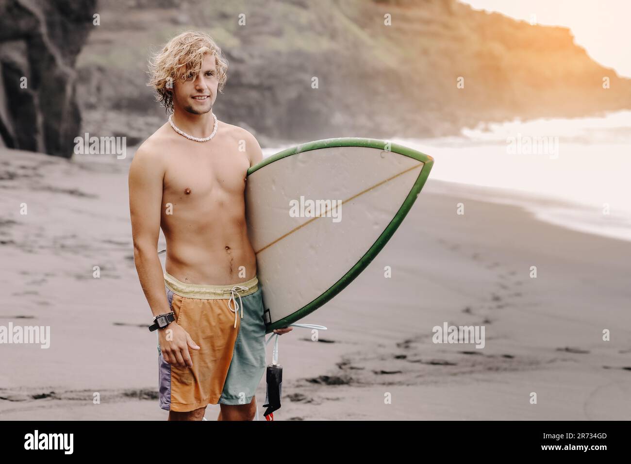 Handsome fit young blond man with mock up surfboard waits for wave to ...