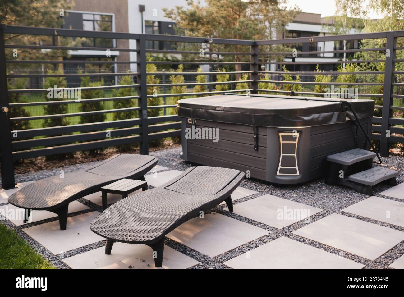 A hot tub and sun loungers in a country house. On the terrace there is ...