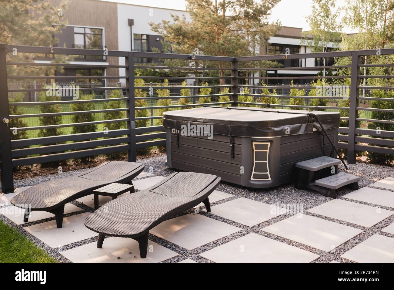 A hot tub and sun loungers in a country house. On the terrace there is ...