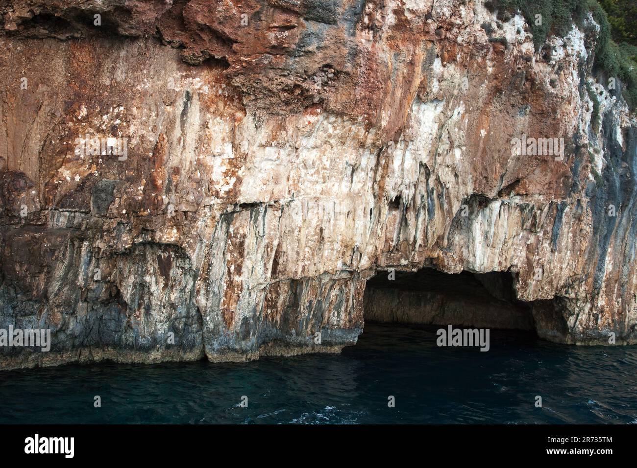 Coastal rock with caves and stone arches. Blue cave, natural landmark ...