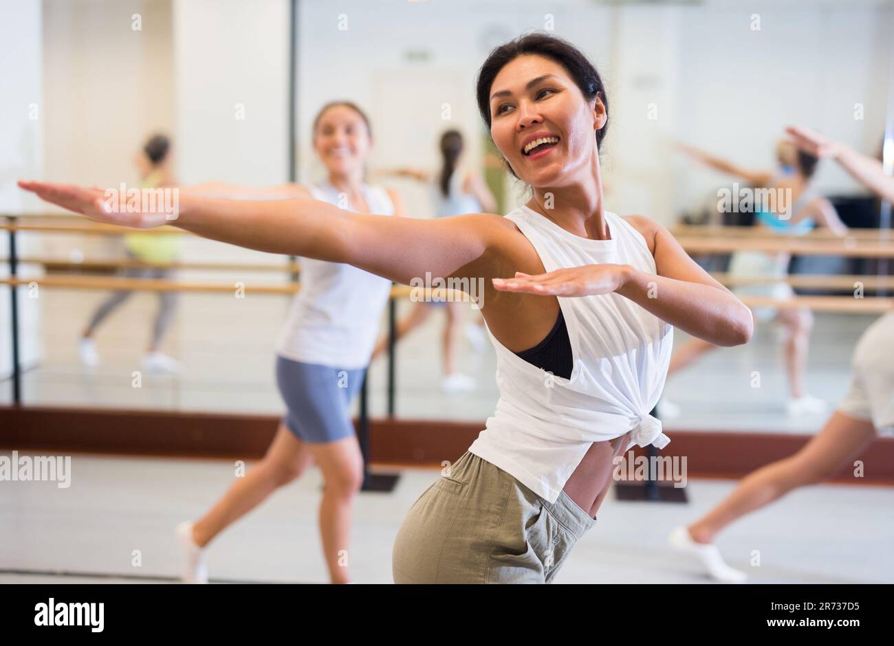 Positive asian woman practices energetic swing in a dance studio Stock ...