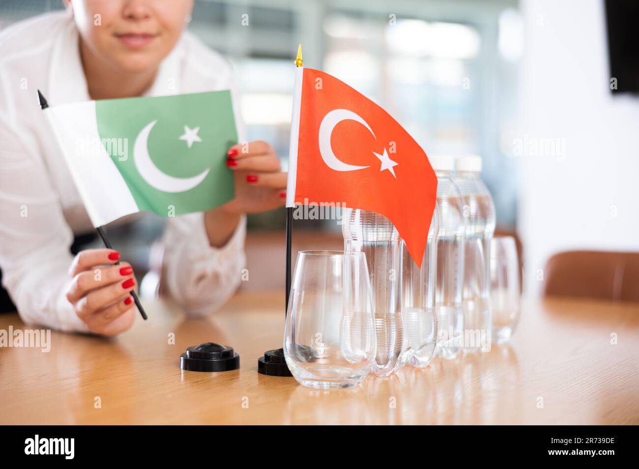 Female employee of the delegation sets flags of countries of Turkey and ...