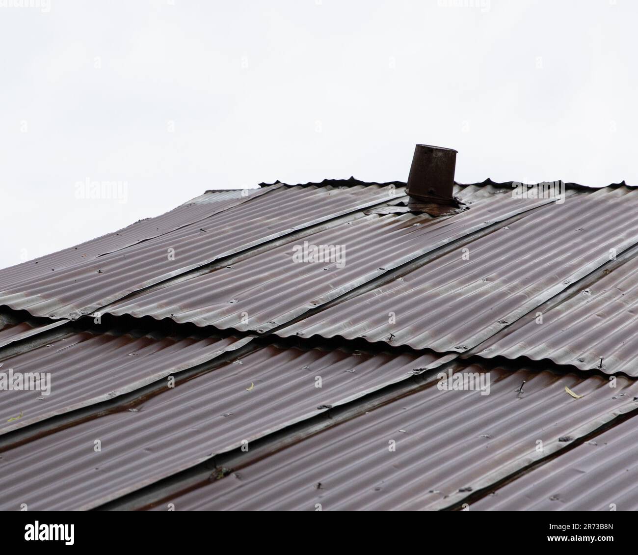 A residential house roof, featuring a single chimney, rooftop structure ...
