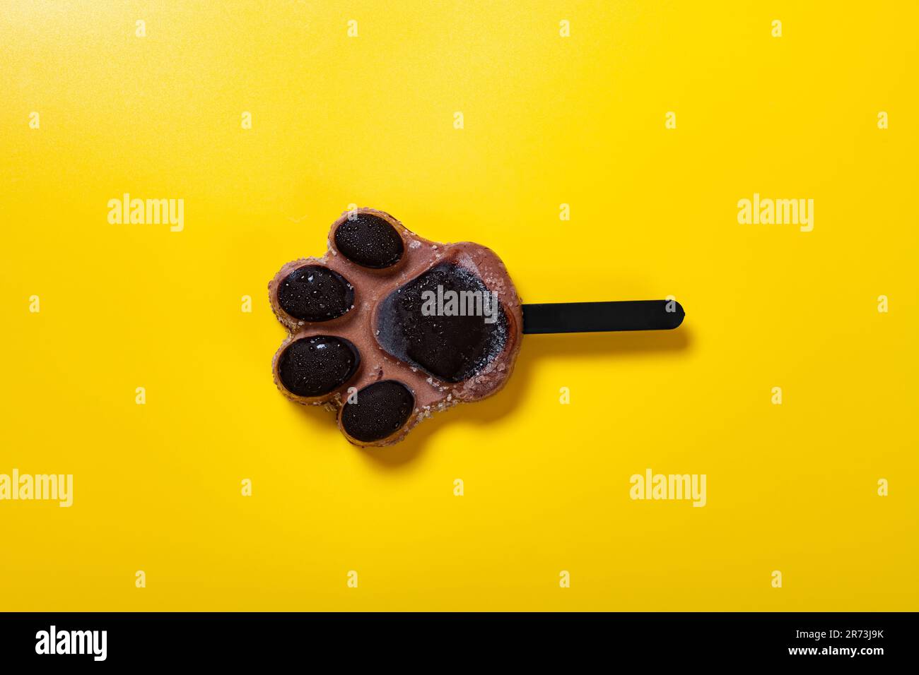 top view bears paw shape chocolate flavor popsicle on yellow background ...