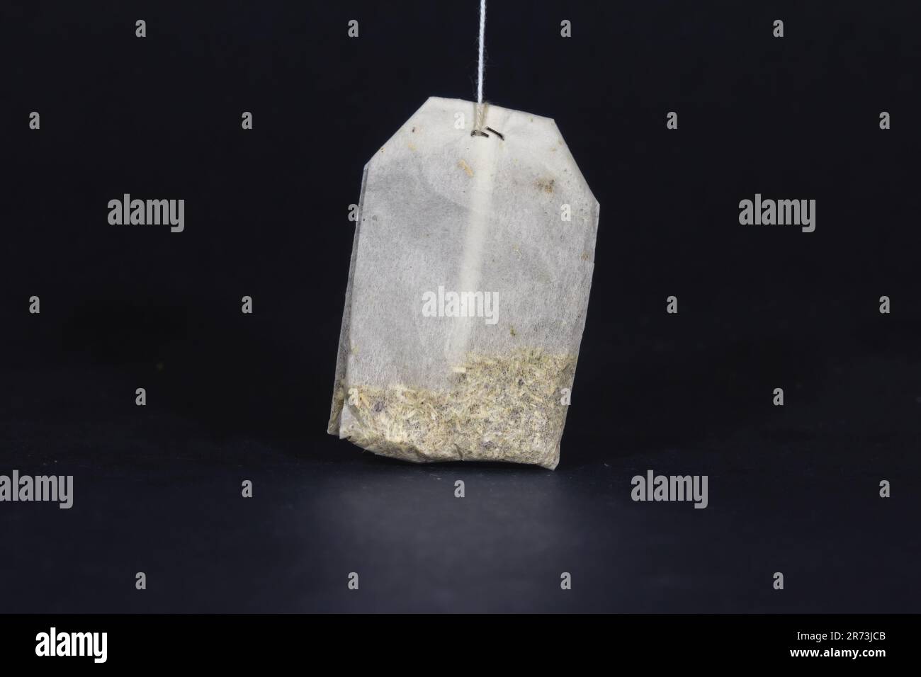 Picture of a paper teabag isolated on a black background. A tea bag, or ...