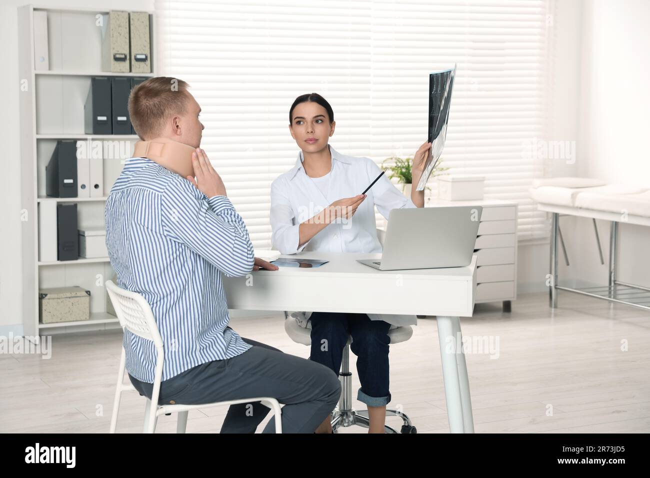 Doctor with neck MRI image consulting patient in clinic Stock Photo - Alamy