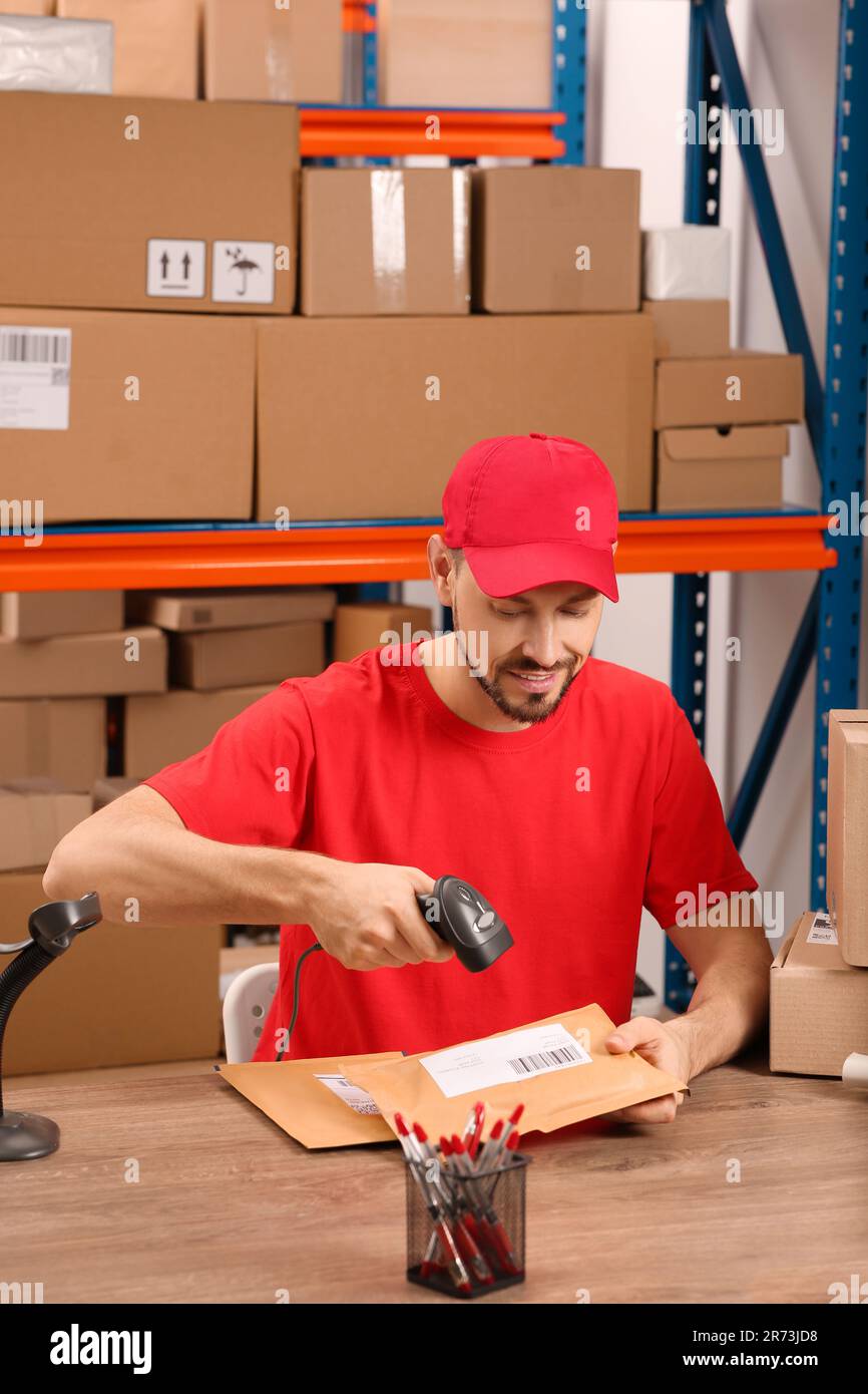 Post office worker with scanner reading parcel barcode at counter ...