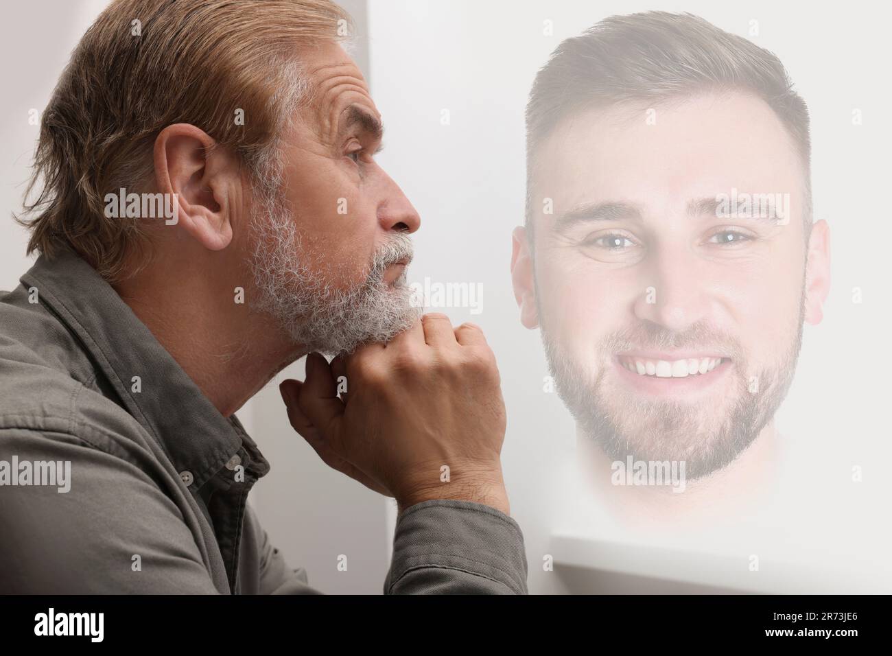 Mature man remembering old times. Translucent picture of young guy ...