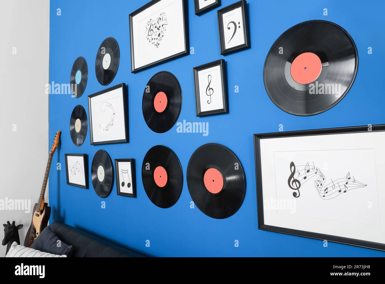 Vinyl records and different pictures on blue wall in living room Stock ...