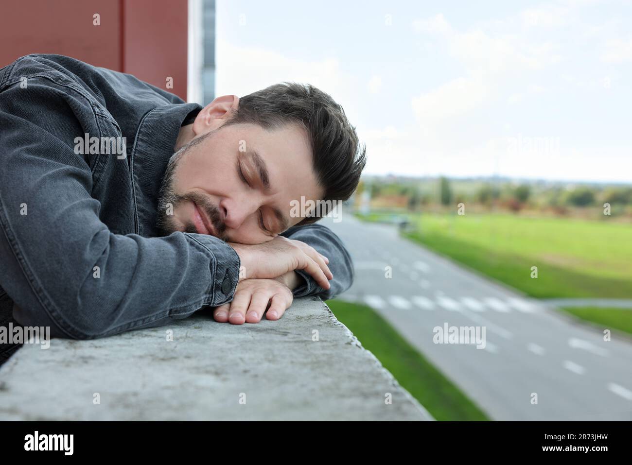Tired man sleeping on stone surface outdoors. Space for text Stock ...