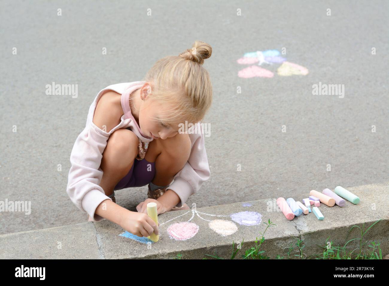 Little child drawing balloons and ukrainian flag with chalk on curb outdoors, space for text ...