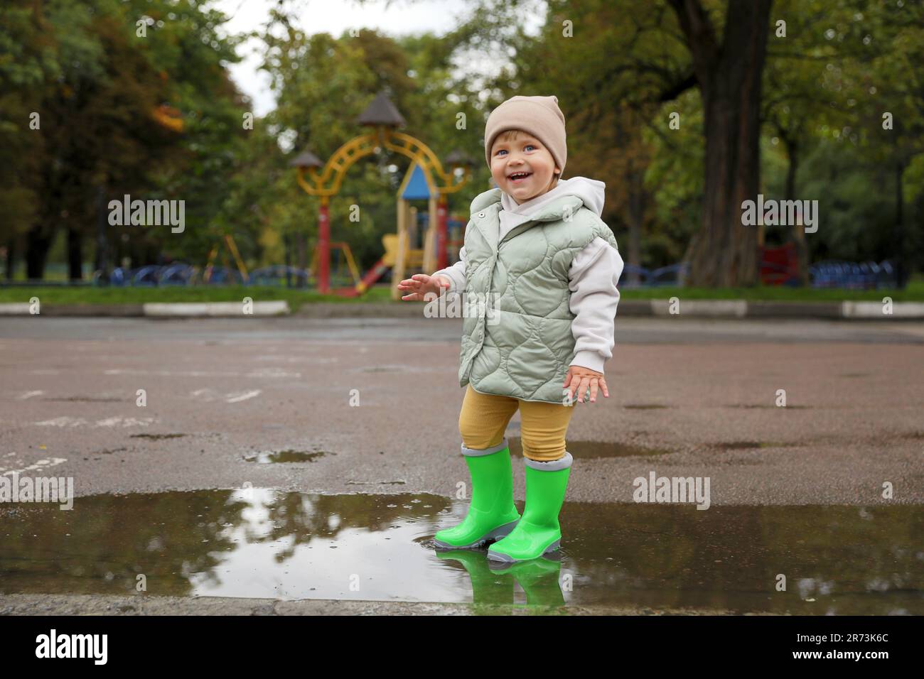 Cute little girl standing in puddle outdoors Stock Photo - Alamy