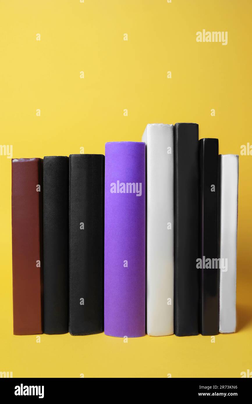 Collection of hardcover books on yellow background Stock Photo - Alamy