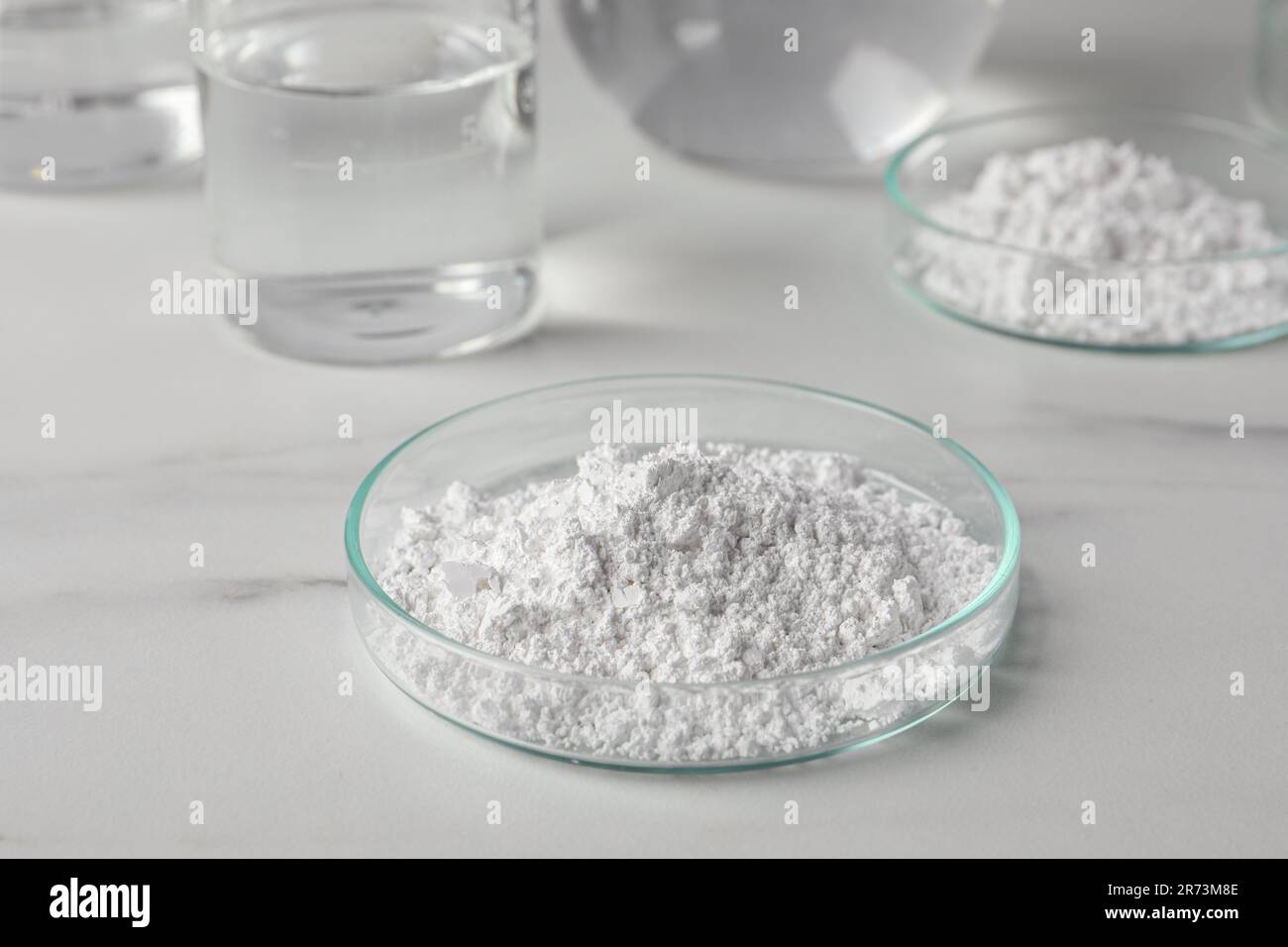 Petri dishes with calcium carbonate powder and laboratory glassware on ...