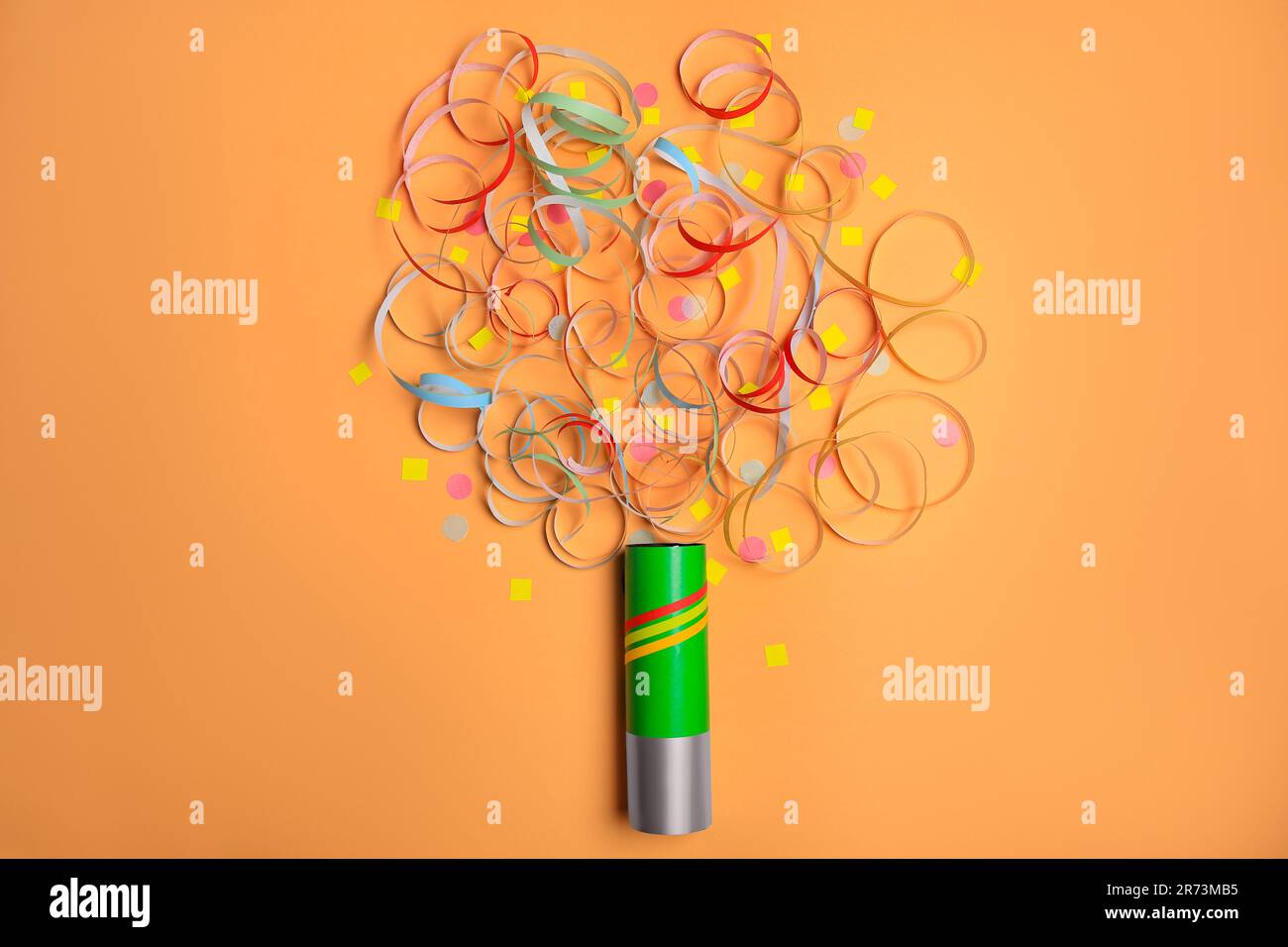 Beautiful Serpentine And Confetti Bursting Out Of Party Popper On Coral Background Flat Lay