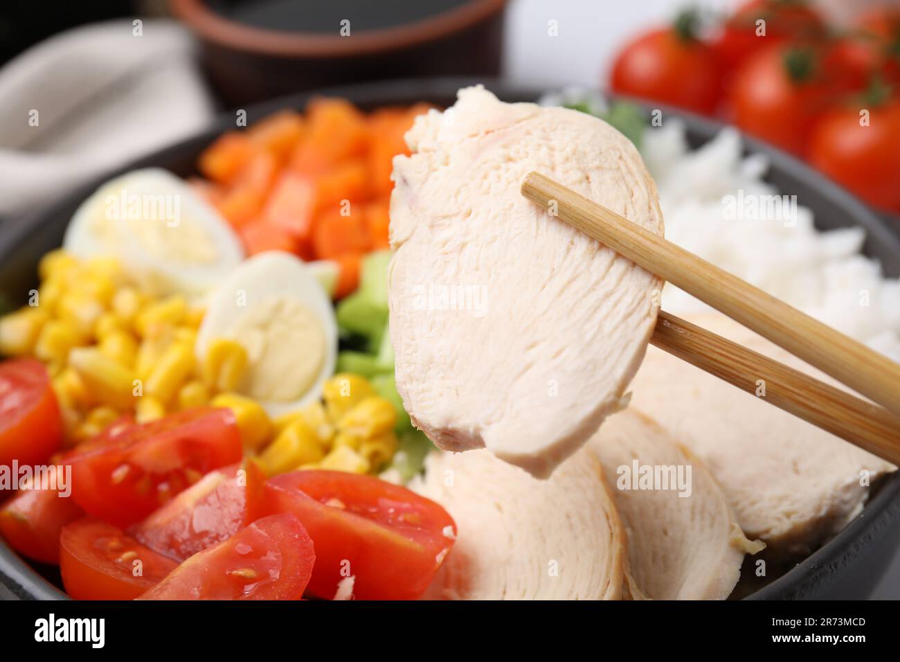Chopsticks with piece of chicken above poke bowl, closeup Stock Photo ...
