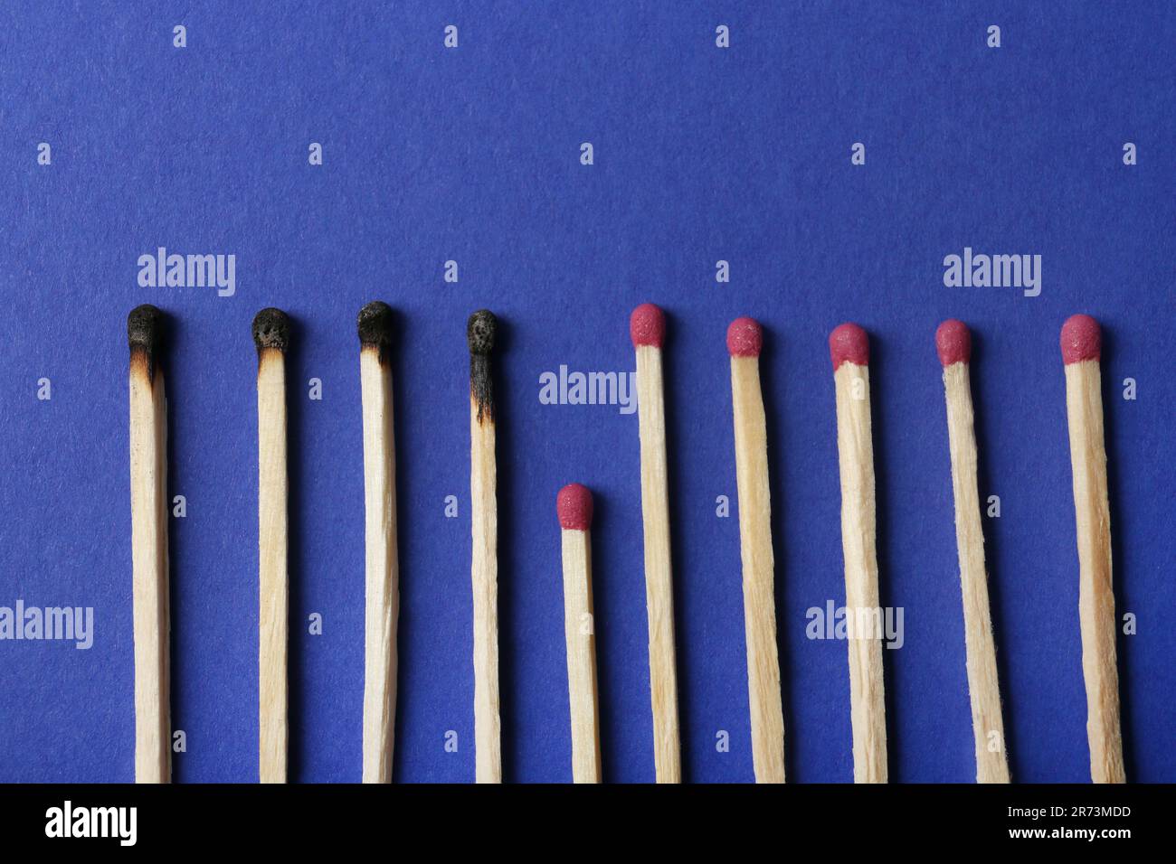 Burnt and whole matches on blue background, flat lay. Stop destruction ...